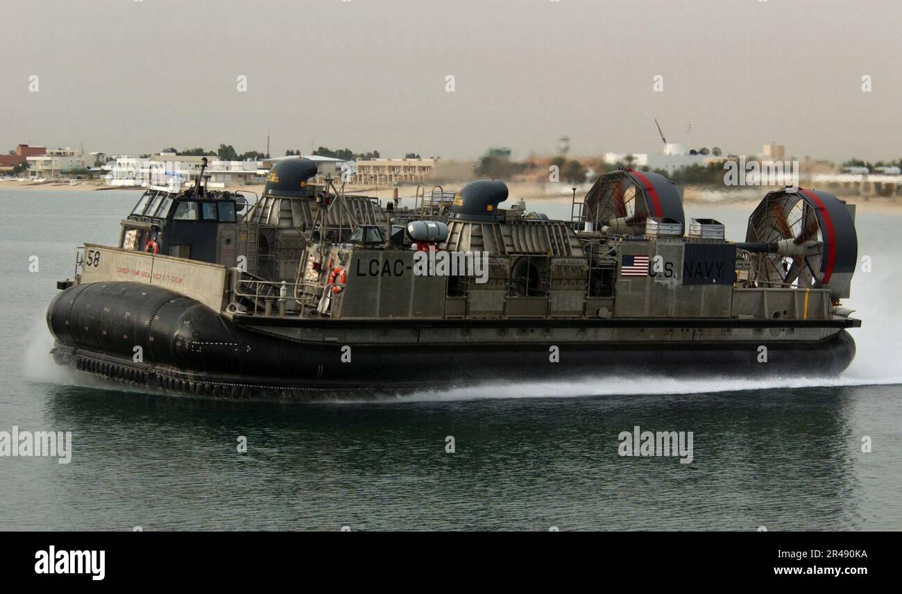 US Navy LCAC departs from a large cement parking pad on a beach Stock ...
