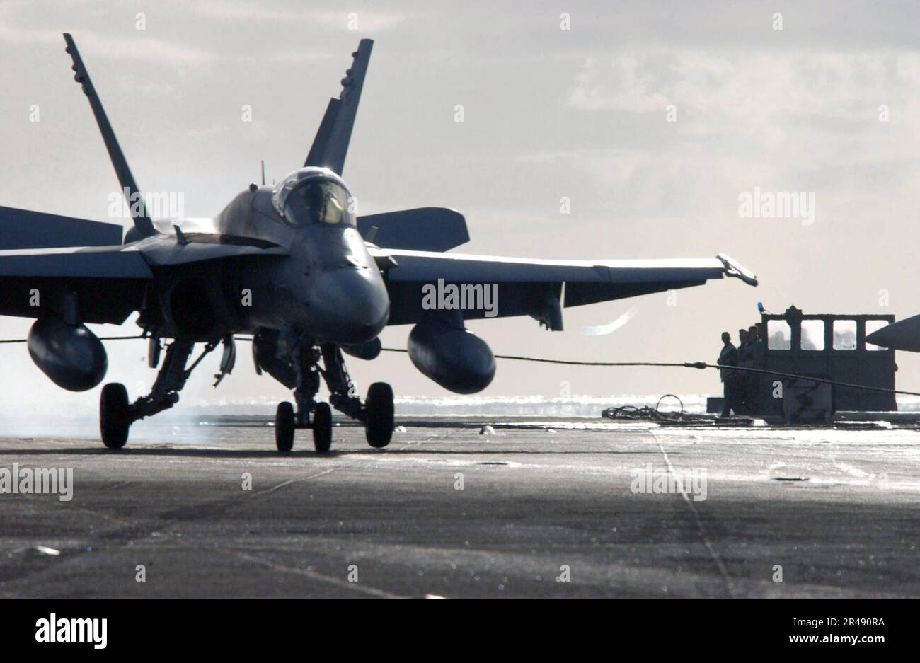 US Navy Landing Signal Officers (LSO) watch as an F-A-18C Hornet ...