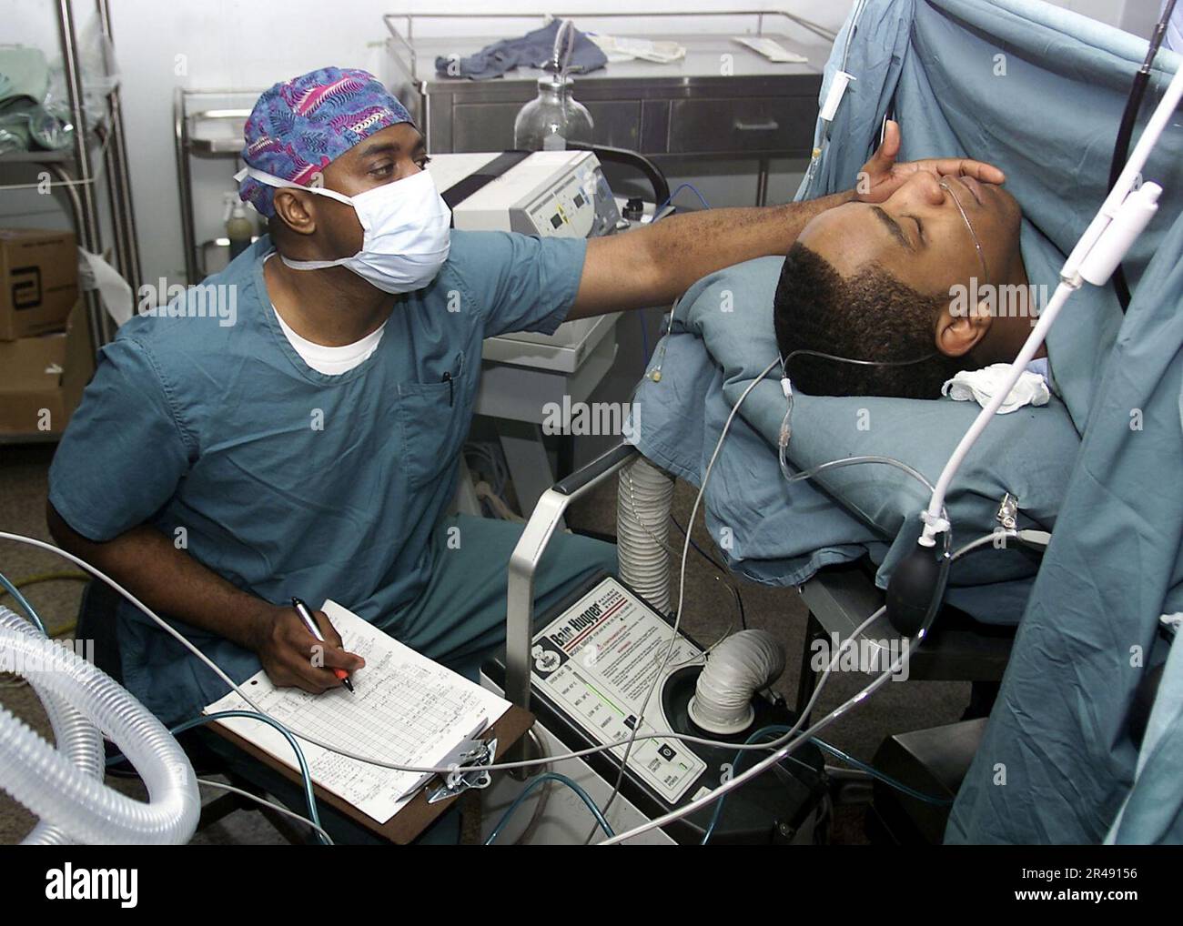 US Navy A doctor monitors the respiration of a patient during surgery ...