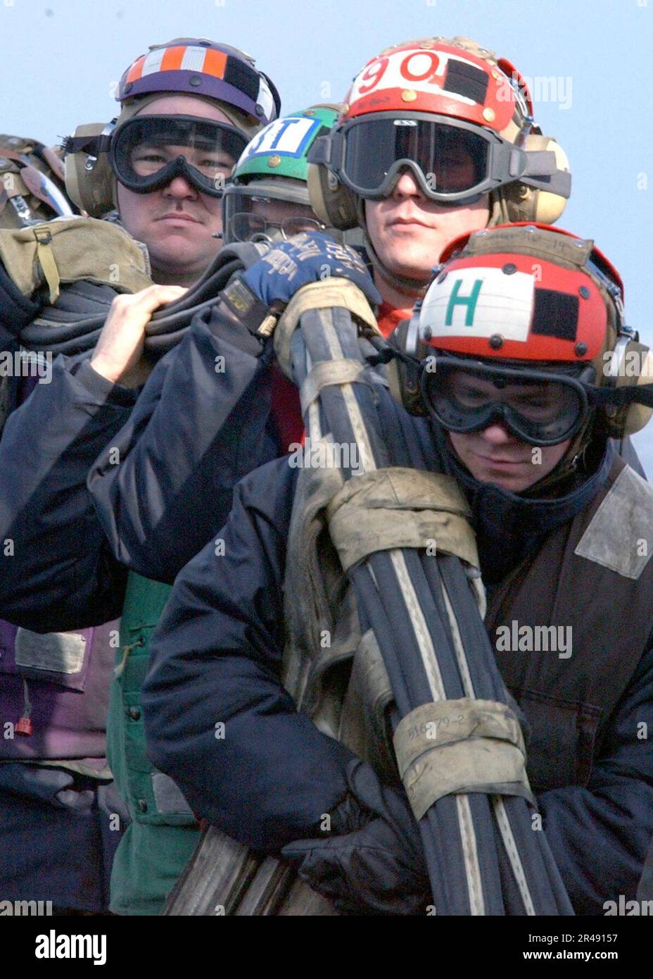 US Navy Flight deck personnel work together to re-stow the fixed wing ...