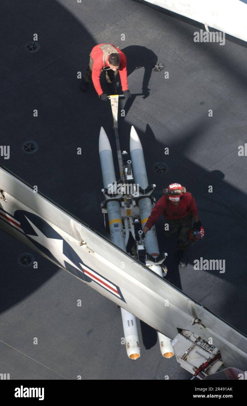US Navy Ordnance Handlers carefully maneuver air-to-air missiles ...