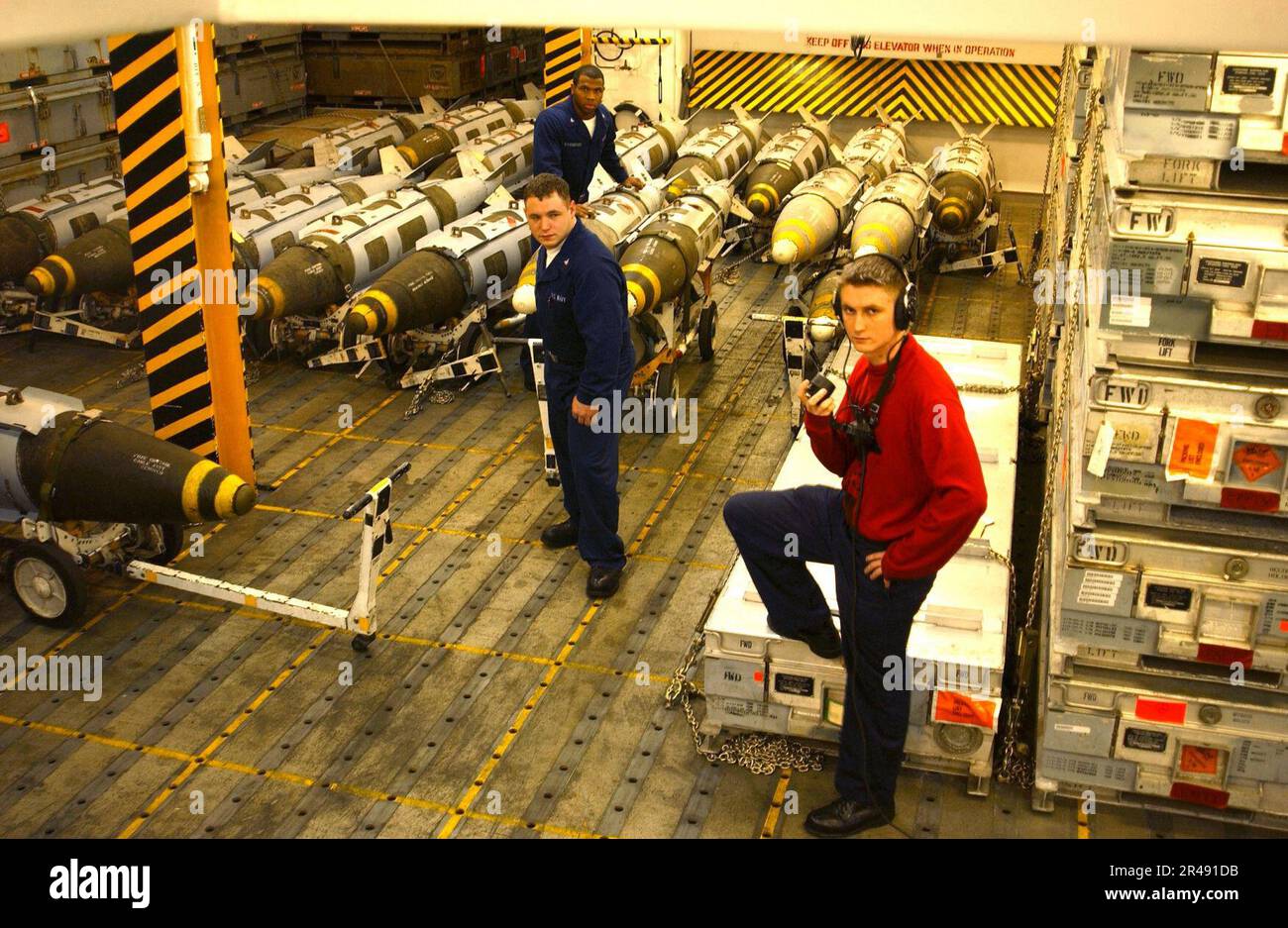 US Navy Weapons handlers in ship's magazine aboard USS Harry S. Truman ...