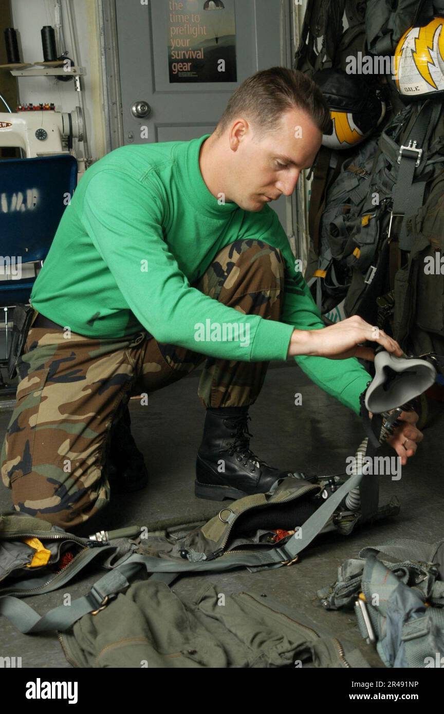 US Navy Aircrew Survival Equipmentman 1st Class performs a preflight ...