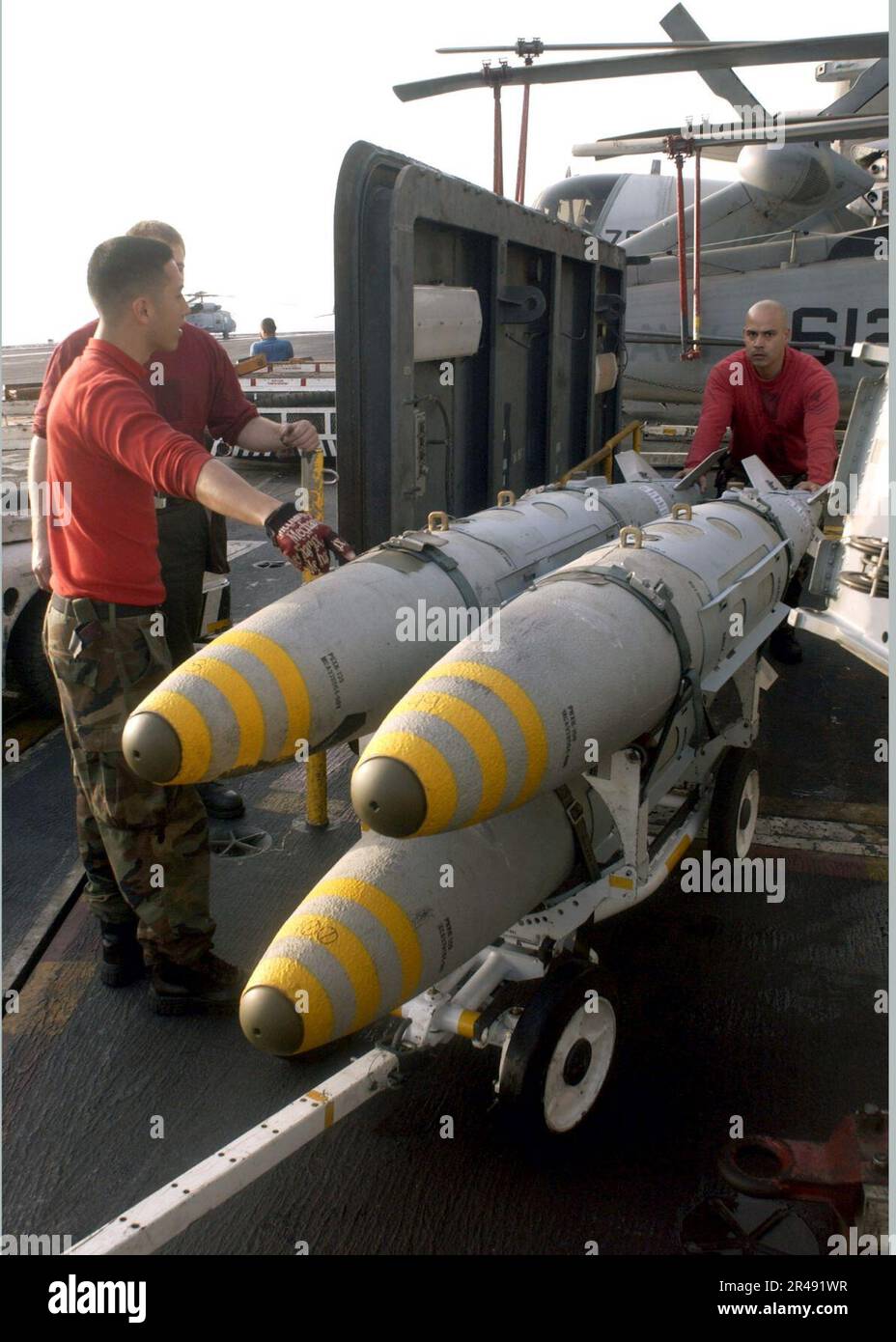 US Navy Aviation Ordnanceman 1st Class pushes bombs off the weapons ...