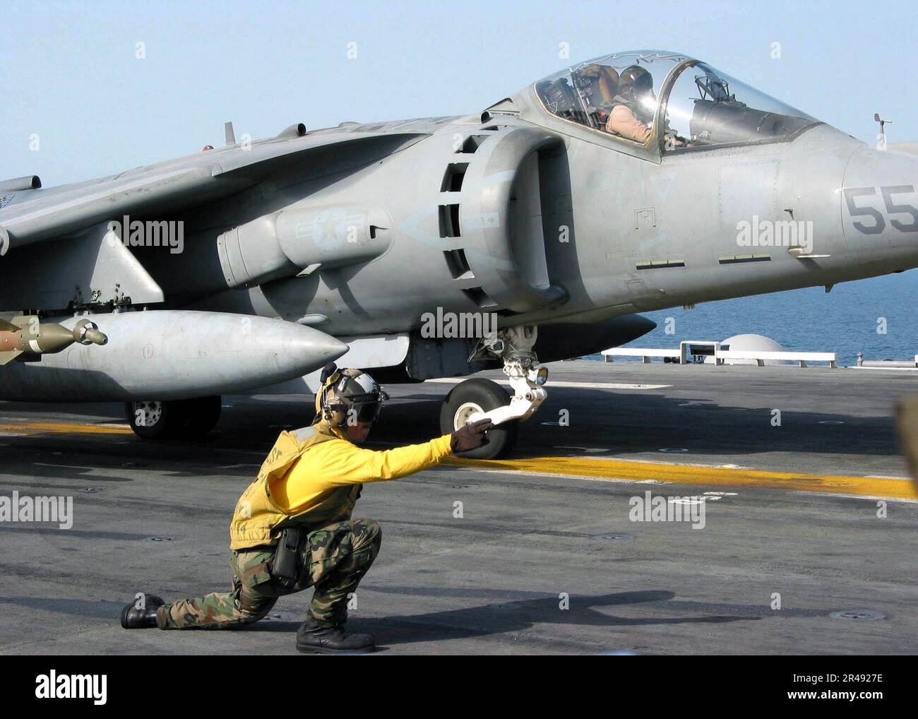 US Navy A flight deck Shooter signals to the pilot of an AV-8B Harrier ...