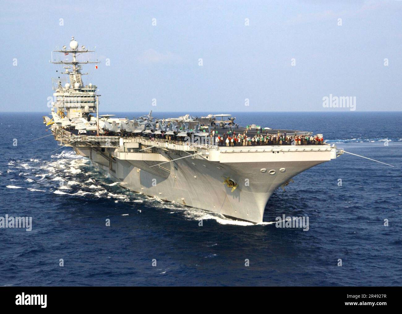 US Navy Crew members gather on the ship's bow to participate in a ...
