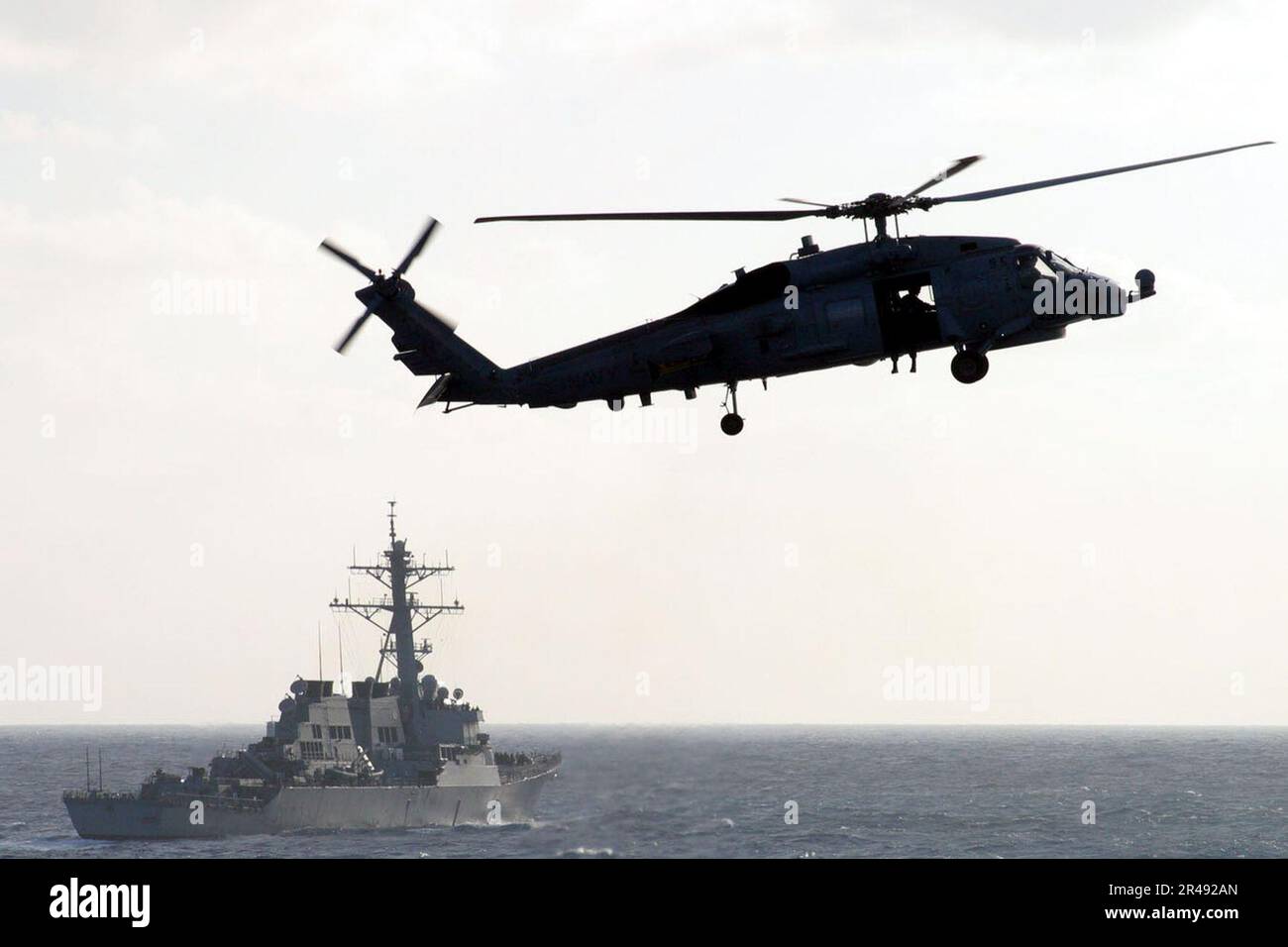 US Navy SH-60F Seahawk patrols the waters astern of the guided missile ...