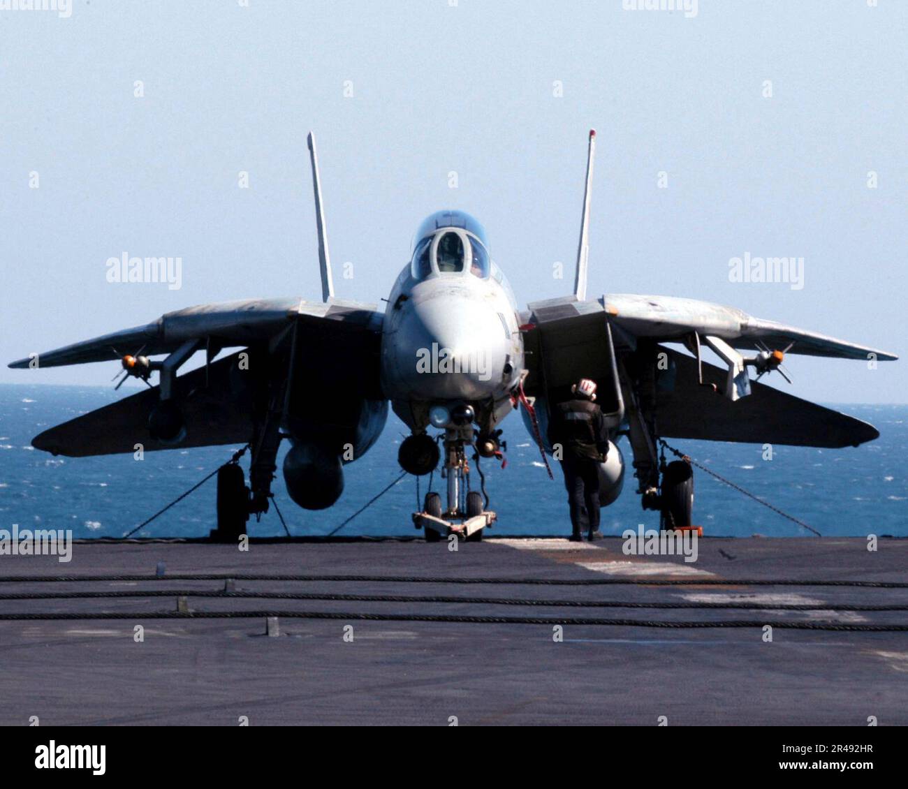 US Navy A plane captain conducts a daily inspection of his F-14D Tomcat ...