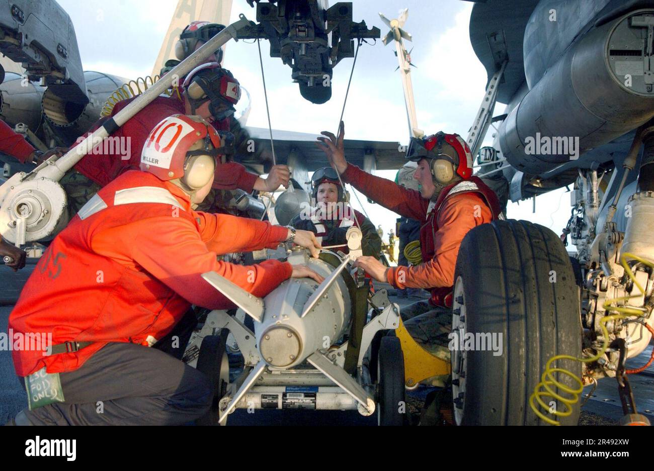 US Navy Aviation Ordnancemen load a two-thousand pound Joint ...