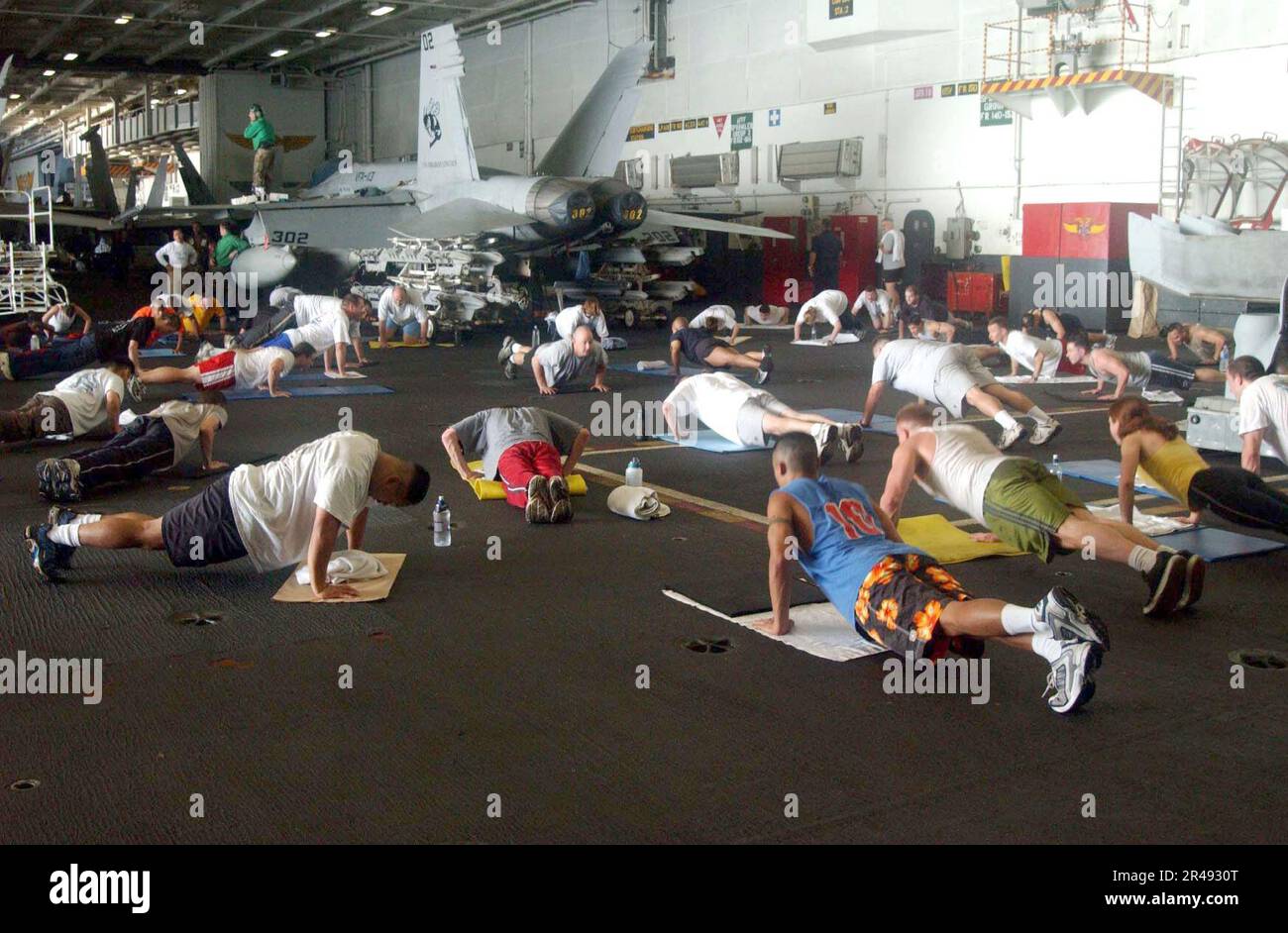 US Navy Sailors participate in a workout led by the ship's Explosive ...