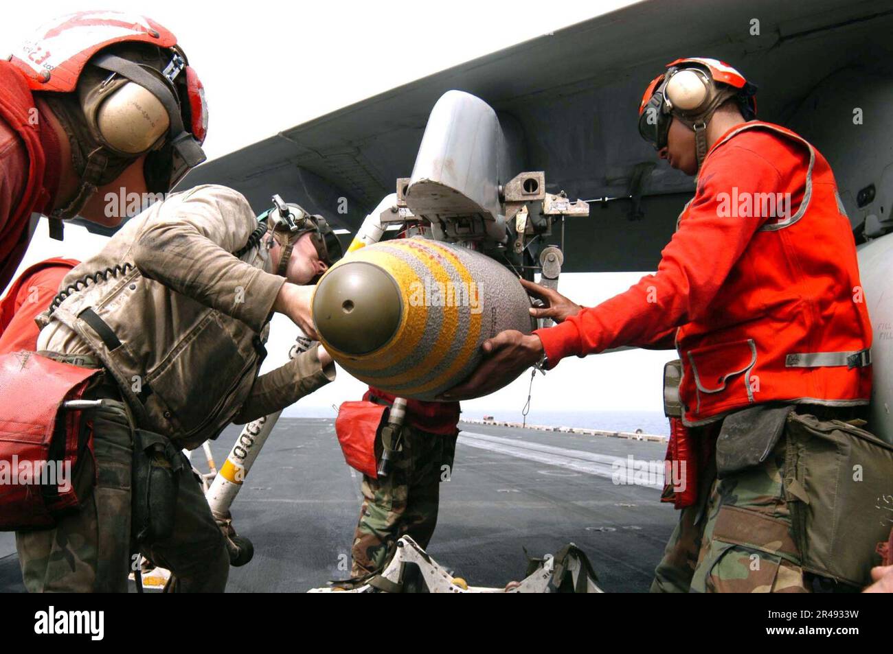 US Navy Aviation Ordnancemen aboard USS Abraham Lincoln (CVN 72) load a ...