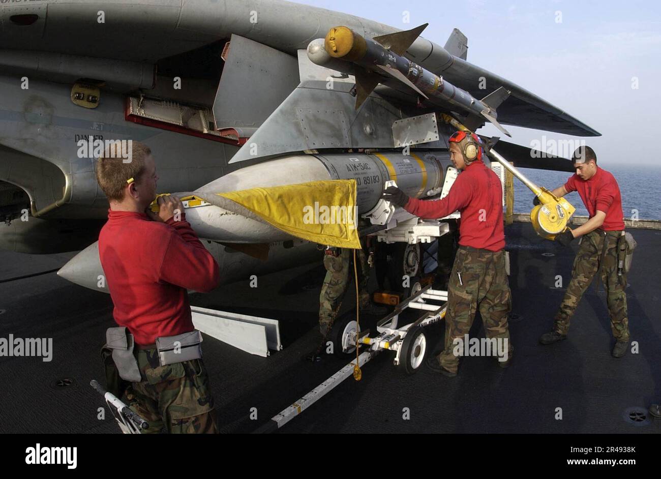 US Navy Aviation Ordnanceman load an AIM-54C Phoenix long-range air-to ...