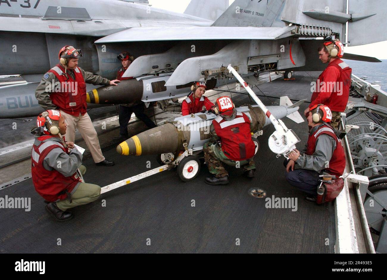US Navy Aviation Ordnancemen rig support suspension equipment to load a ...
