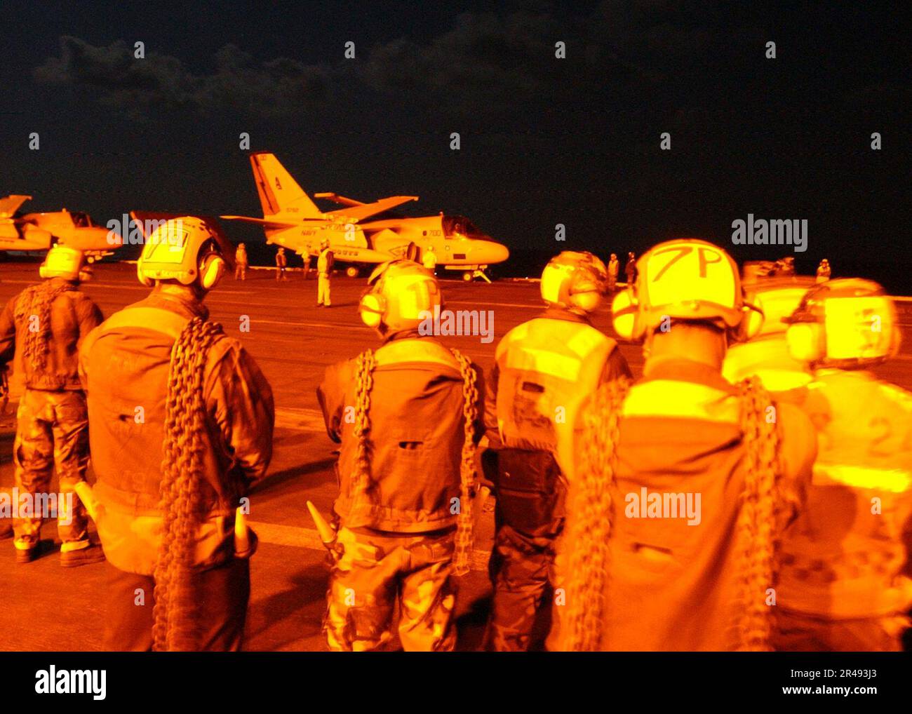 US Navy Flight deck personnel stand at the ready while an S-3B Viking ...
