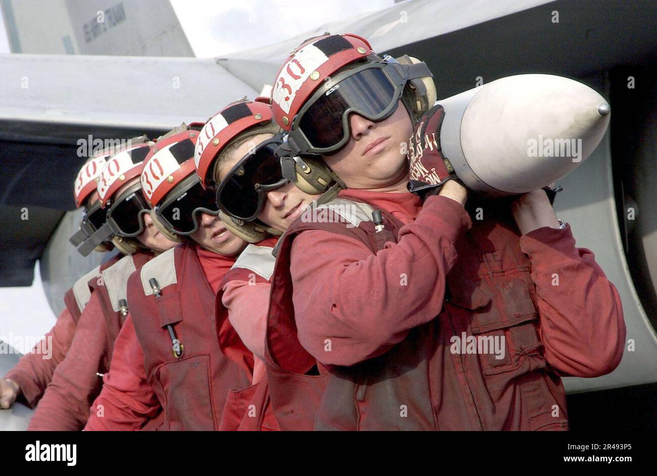 US Navy Aviation Ordnancemen unload ordnance from an F-A-18 Hornet on ...
