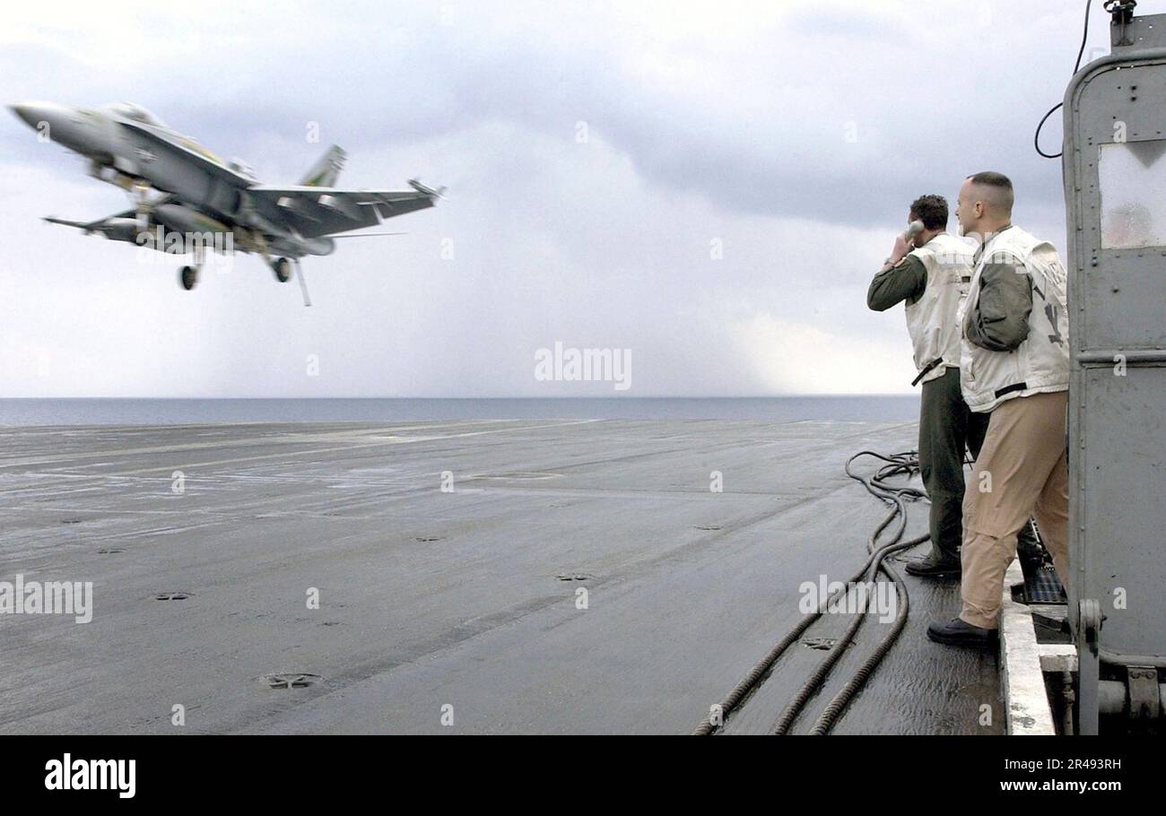 US Navy Landing Signals Officers (LSOs) observe the recovery of an F-A ...