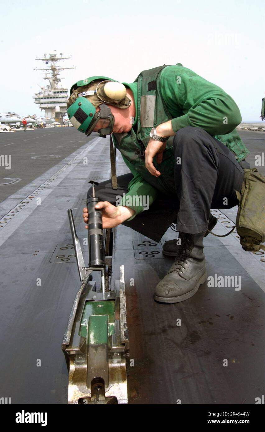 US Navy A sailor performs maintenance on one of four catapults before ...