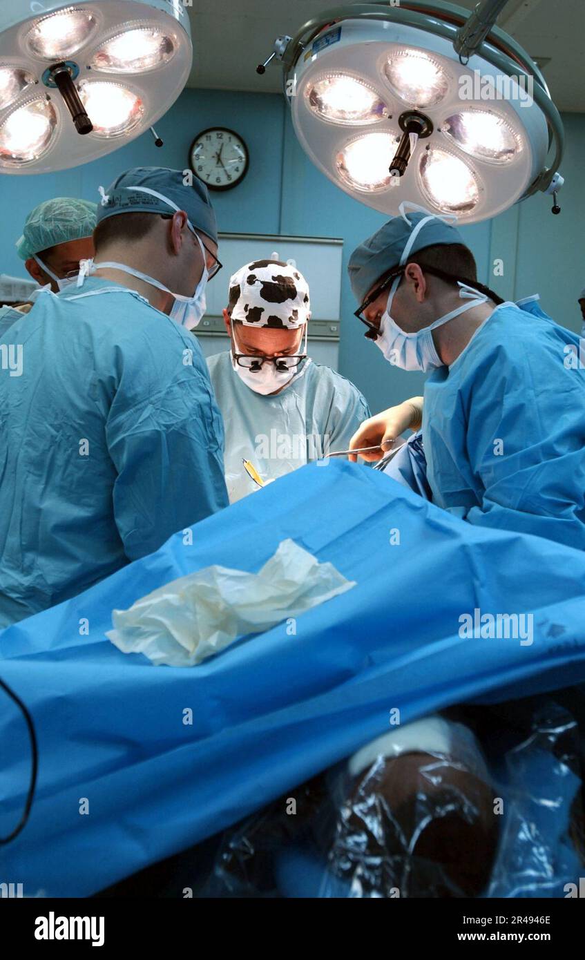 US Navy Surgeons work diligently on an enemy prisoner of war (EPW) in ...