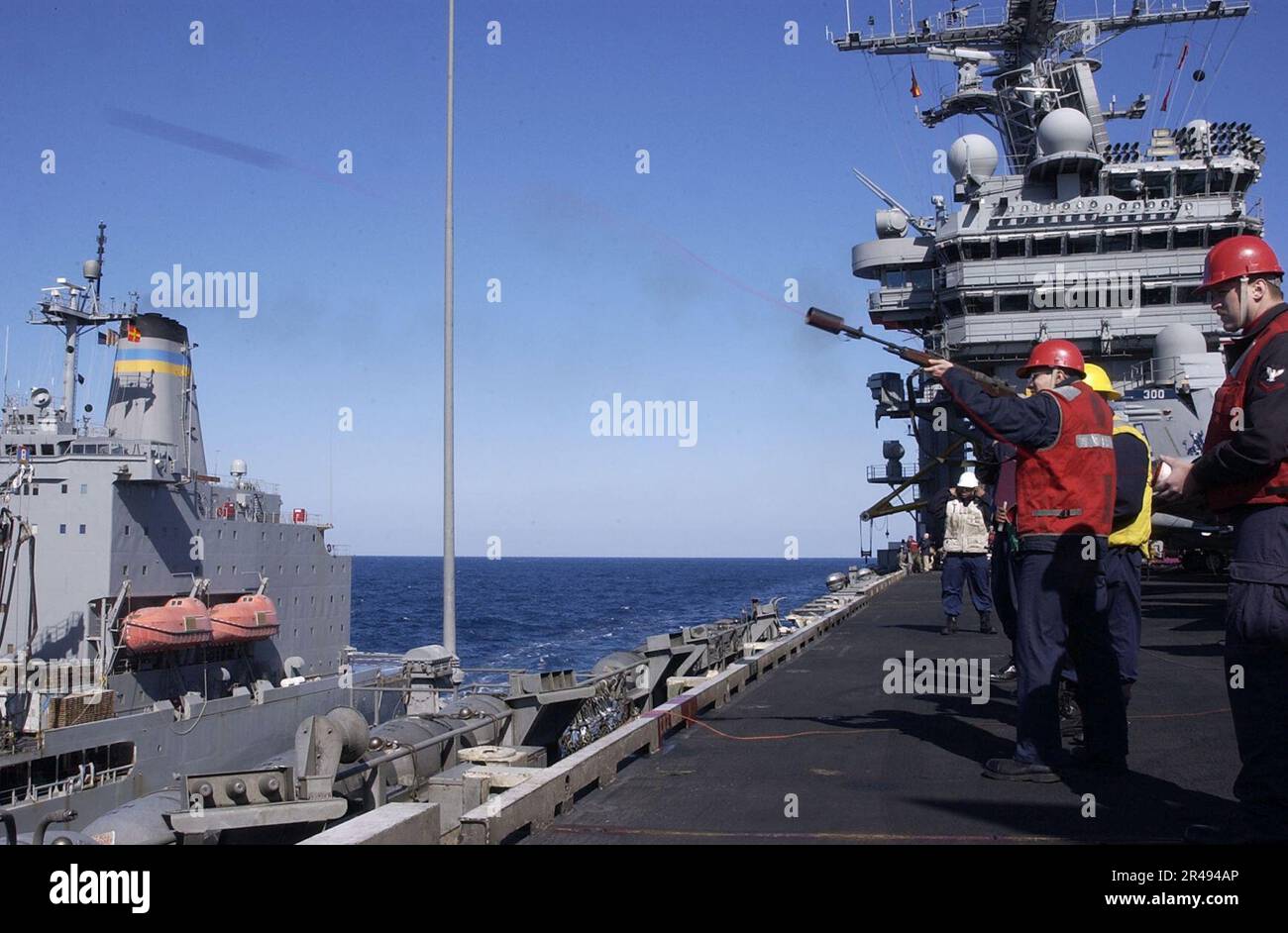 US Navy Gunner's Mates fire the messenger line from USS Harry S. Truman ...