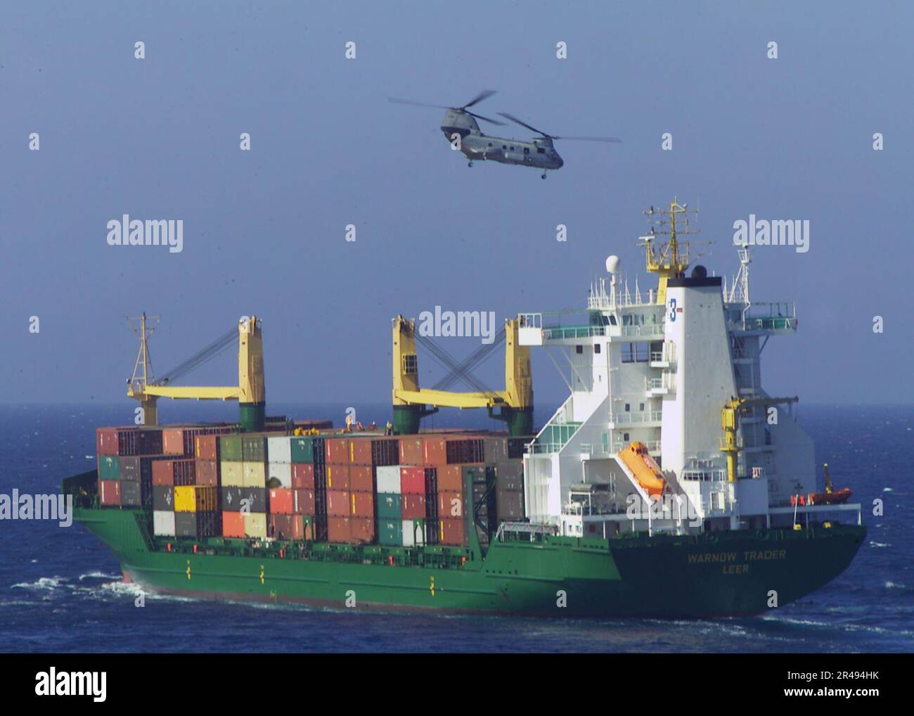 US Navy A CH-46 Sea Knight helicopter performs a vertical replenishment ...