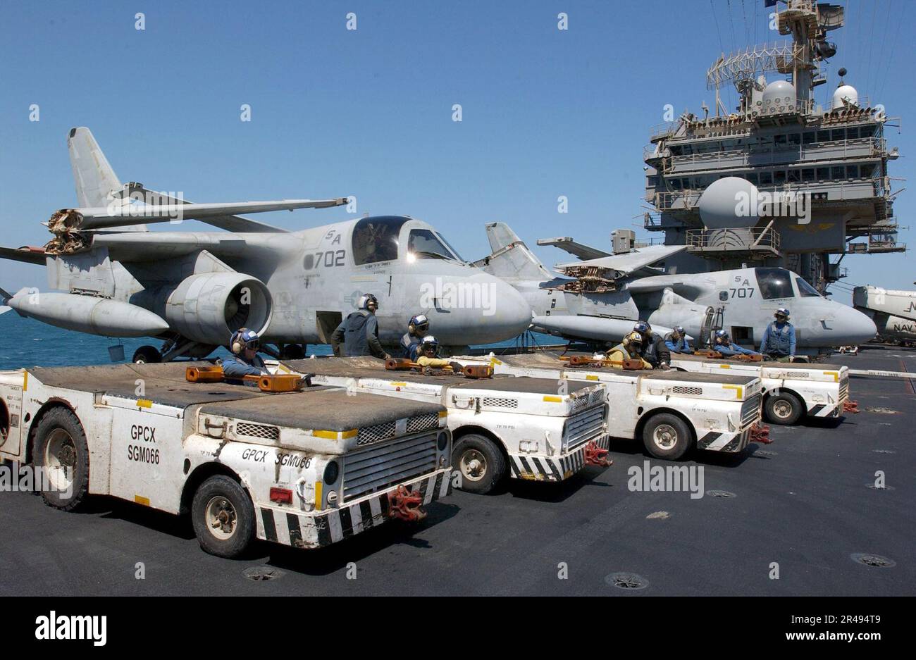 US Navy Tow tractors are positioned on the starboard side of the flight ...