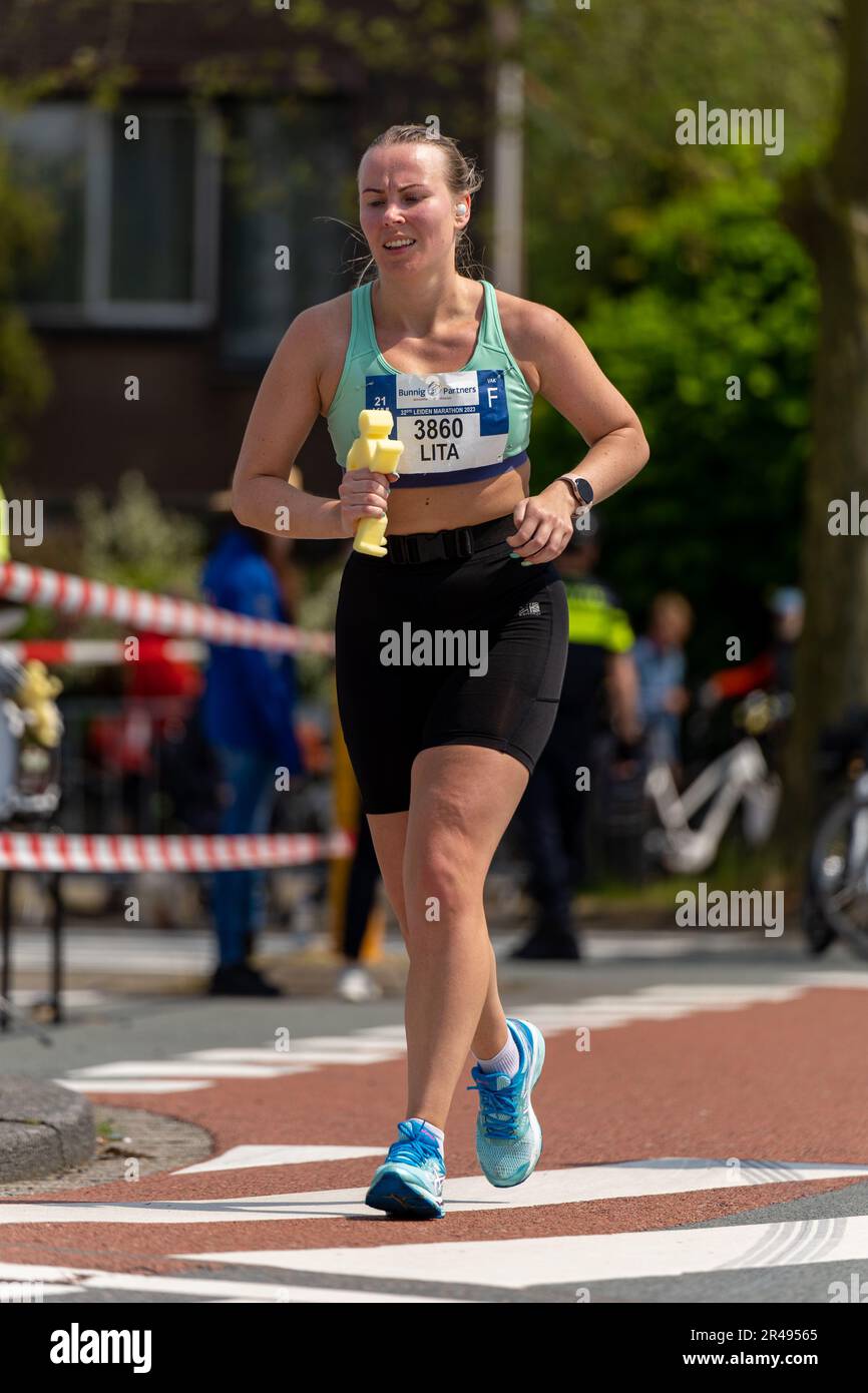 A woman running along the road during a marathon in Leiden Stock Photo - Alamy