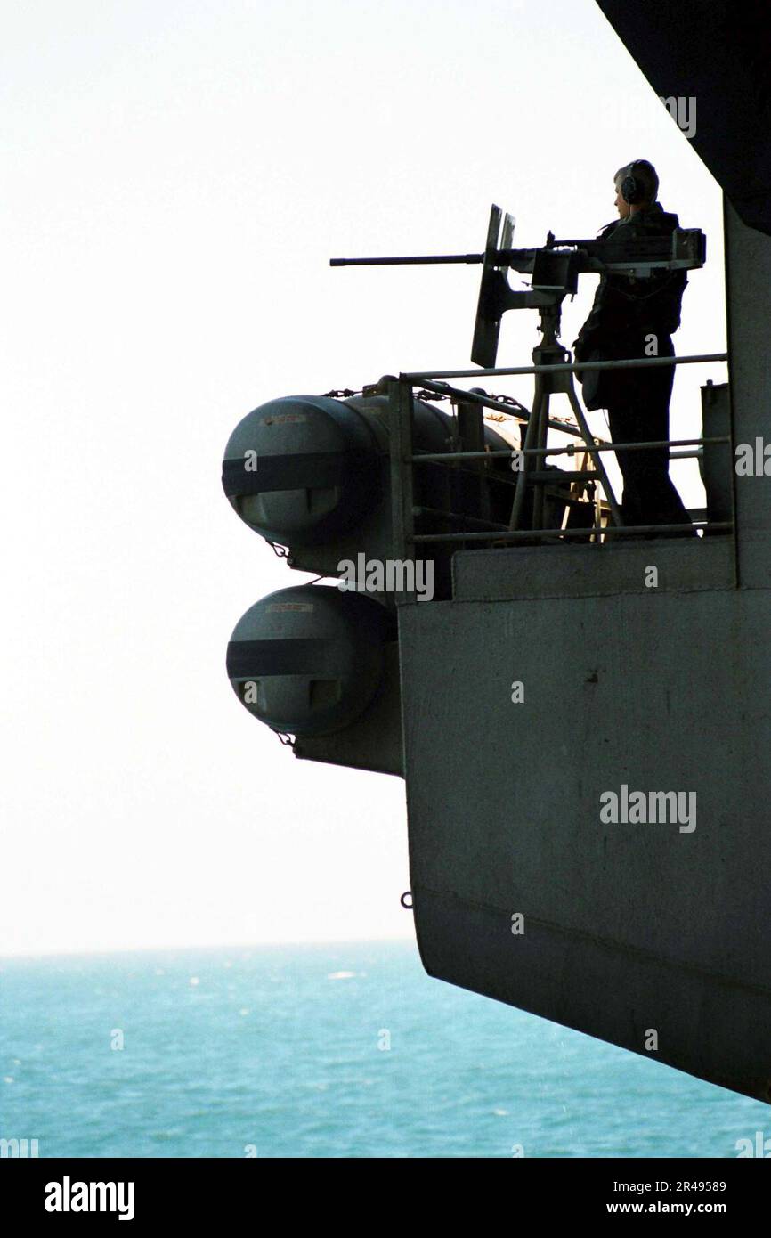 US Navy A lone Sailor stands watch with one of the .50 caliber gun ...