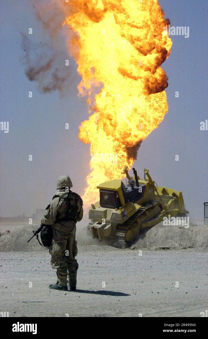US Navy A U.S. Army soldier stands guard duty near a burning oil well ...