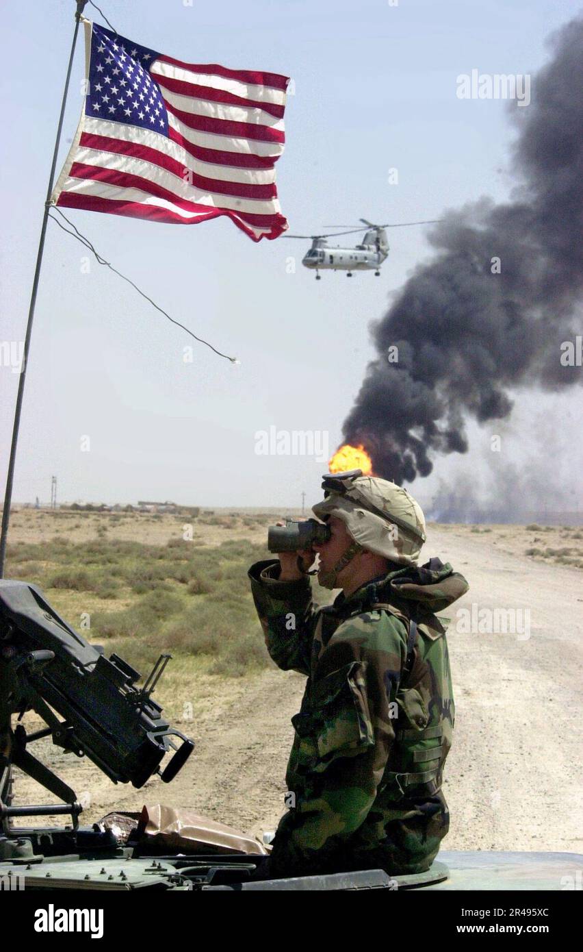 US Navy A U.S. Army soldier stands guard duty near a burning oil well ...