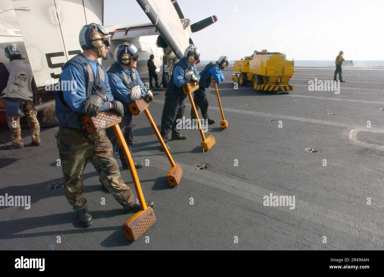 US Navy Aviation Boatswain's Mates stand by to chock various landing ...