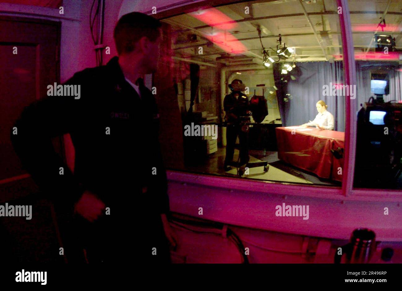 US Navy Crew members run the production of the evening news broadcast ...