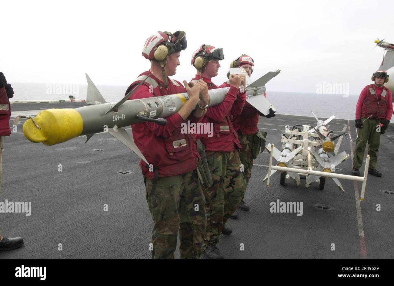 US Navy Aviation Ordnancemen lift an AIM-9M Sidewinder air-to-air ...