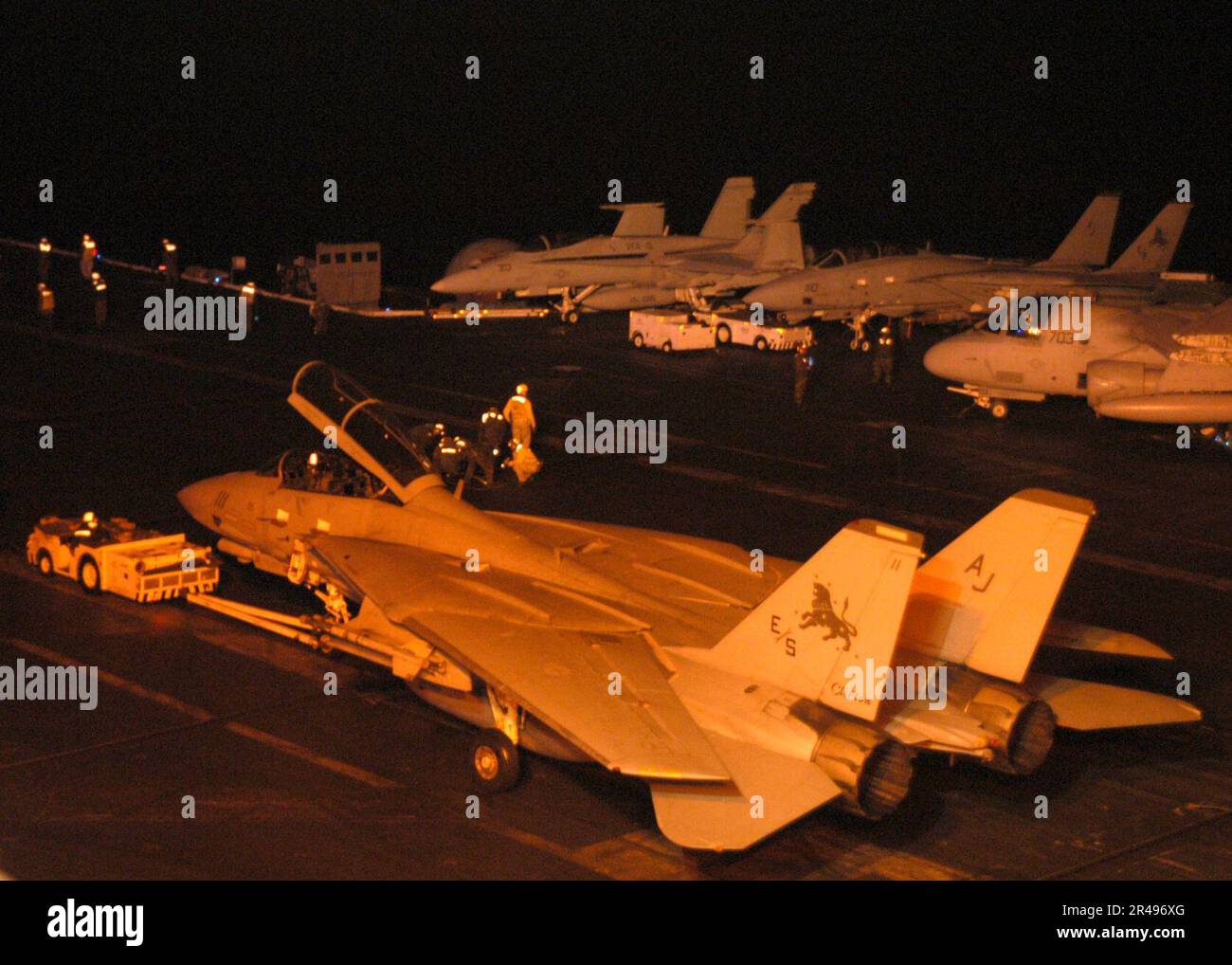 US Navy A tractor is used to move an F-14 Tomcat on the flight deck ...