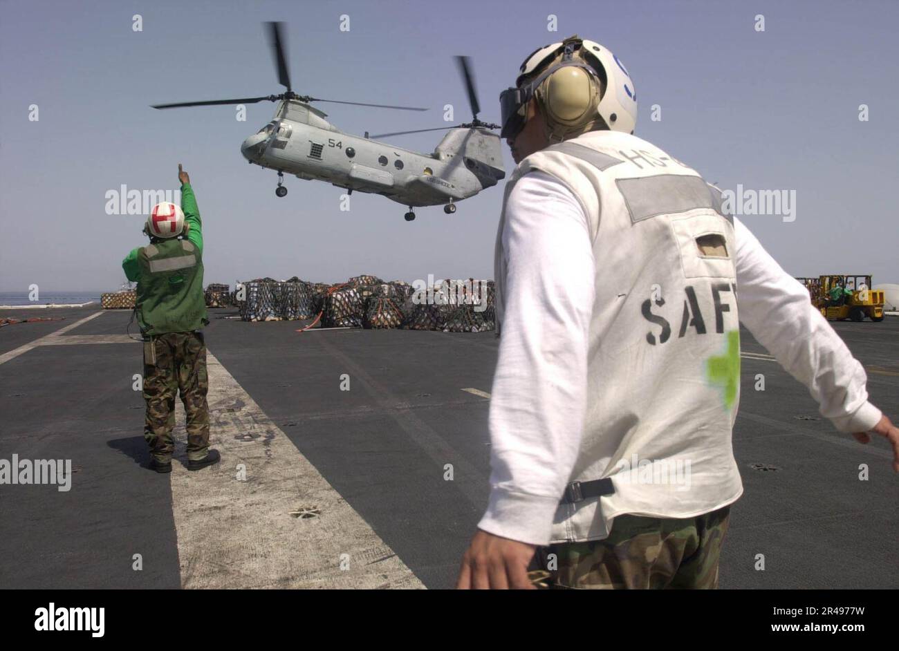 US Navy Crewmembers recover a CH-46 Sea Knight on the flight deck ...
