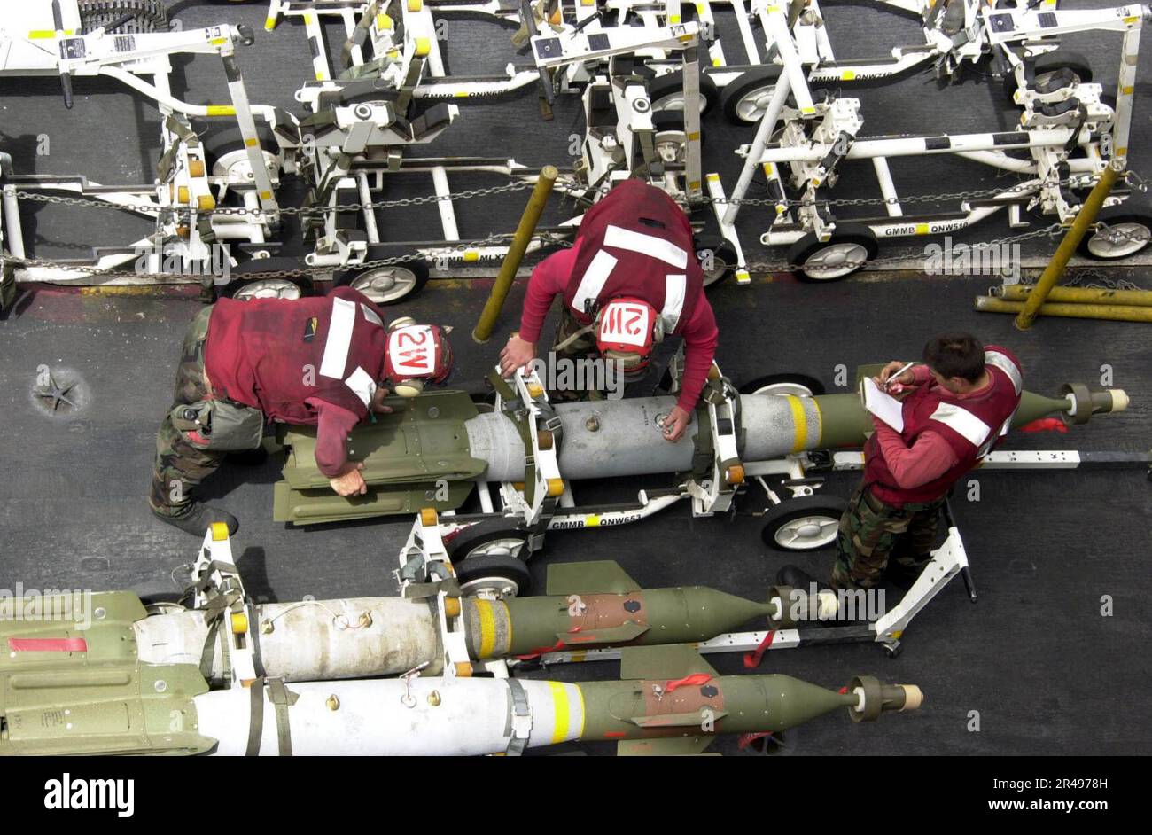 US Navy Aviation Ordnancemen re-inspect a 500lb Guided Bomb Unit Twelve (GBU-12) before loading ...