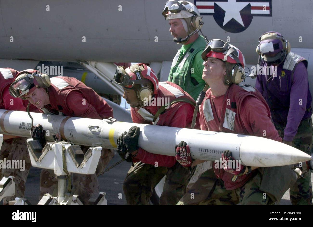 US Navy Aviation Ordnanceman lift an AIM-120 Advanced Medium-Range Air ...