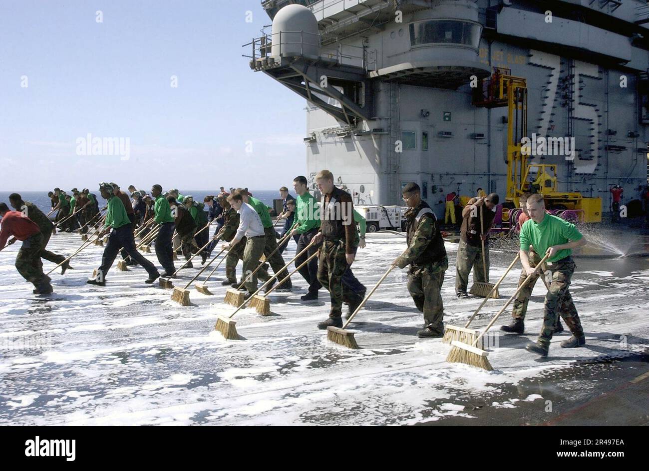 US Navy Sailors scrub down the flight deck during a scrub-ex aboard USS ...