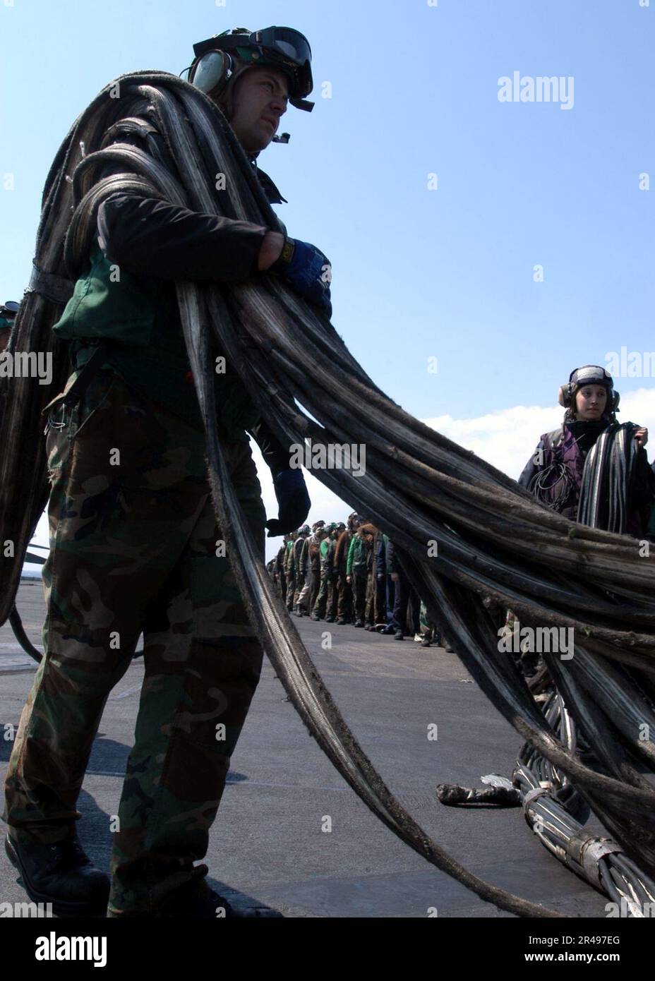 US Navy Crewmembers re-stow an aircraft barricade after a flight deck ...