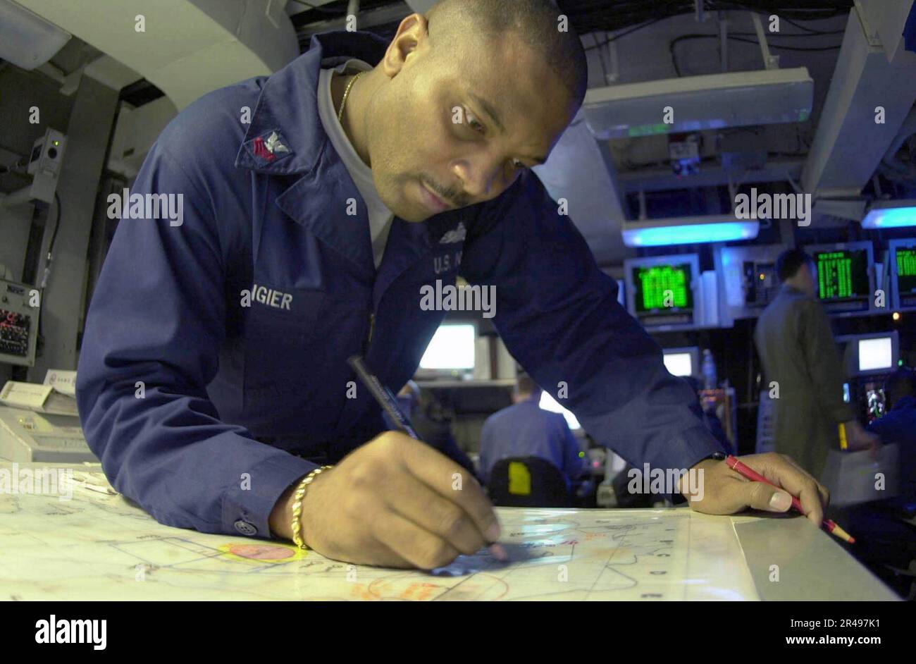 US Navy Operations Specialist 1st Class uses a compass to plot a ...