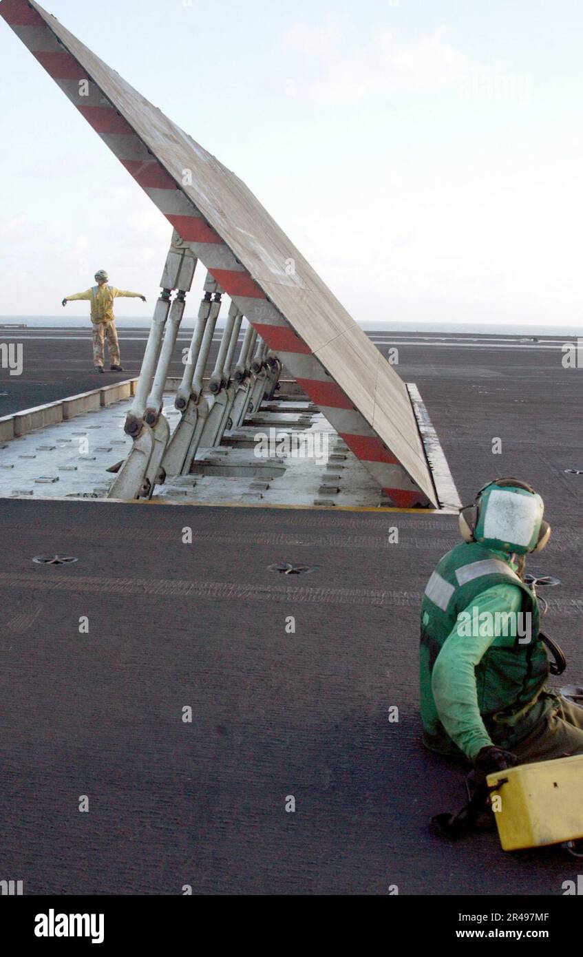 US Navy A Flight Deck Officer signals to the Jet Blast Deflector (JBD ...