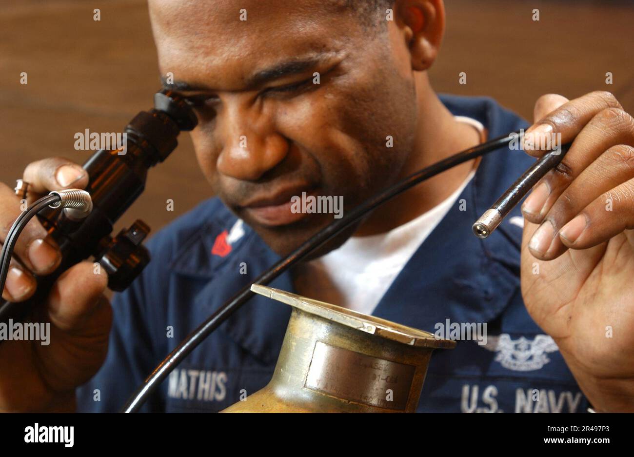 US Navy Aviation Machinist's Mate 1st Class uses a bore scope fiber ...