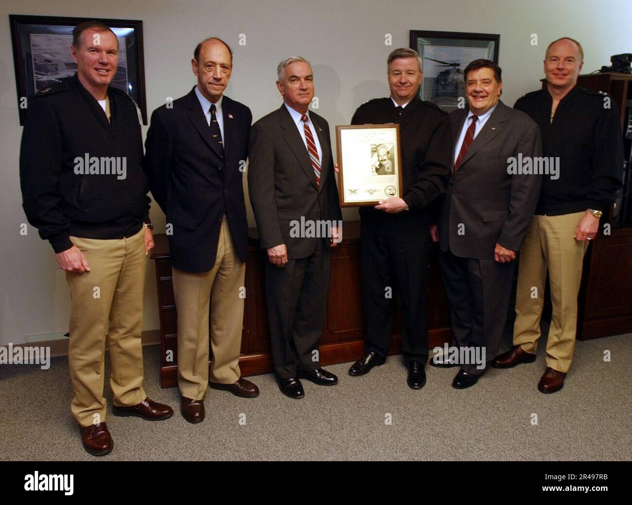 US Navy Rear Adm. P. D. Smith displays a plaque presented in honor of ...