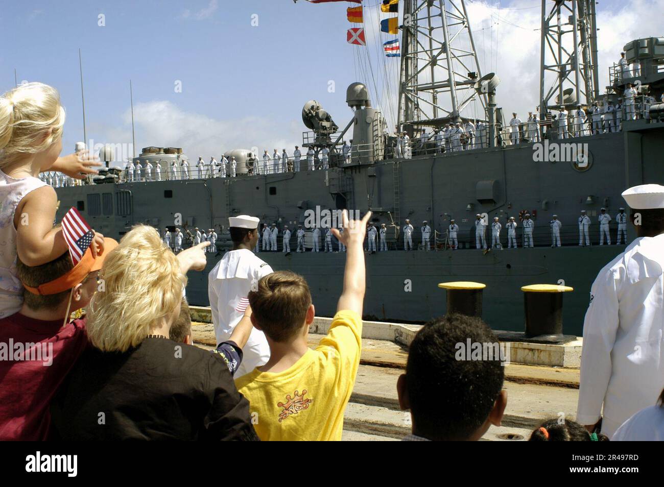 US Navy Family and friends wave to sailors onboard the guided missile ...