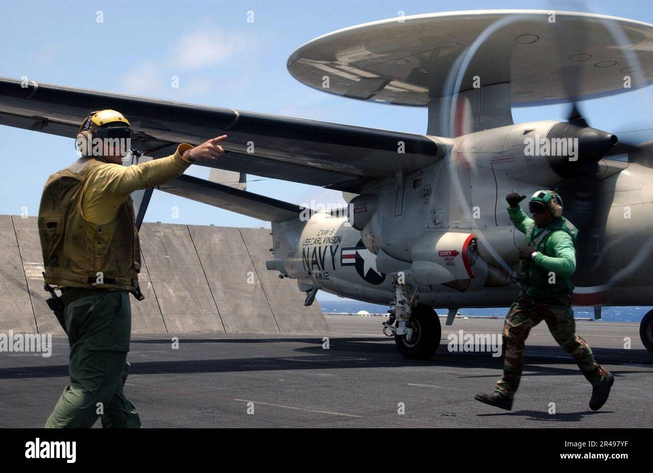 US Navy Aviation Boatswain's Mates communicate via hand signals as an E ...