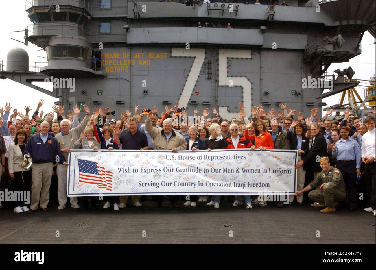 US Navy Sailors and Marines gather on the flight deck in front of the ...