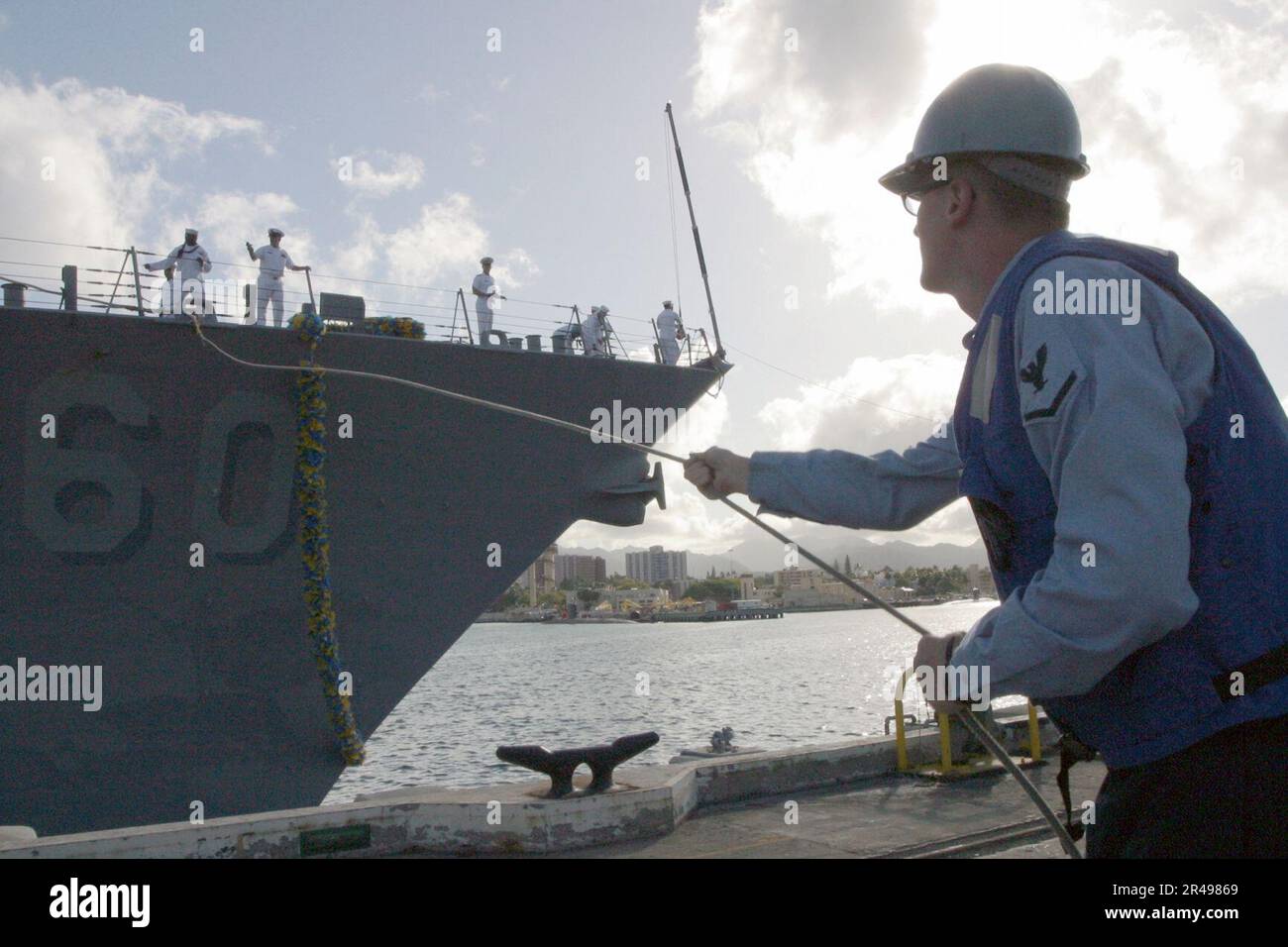 US Navy A Naval Station Pearl Harbor line-handler helps moor USS Paul ...