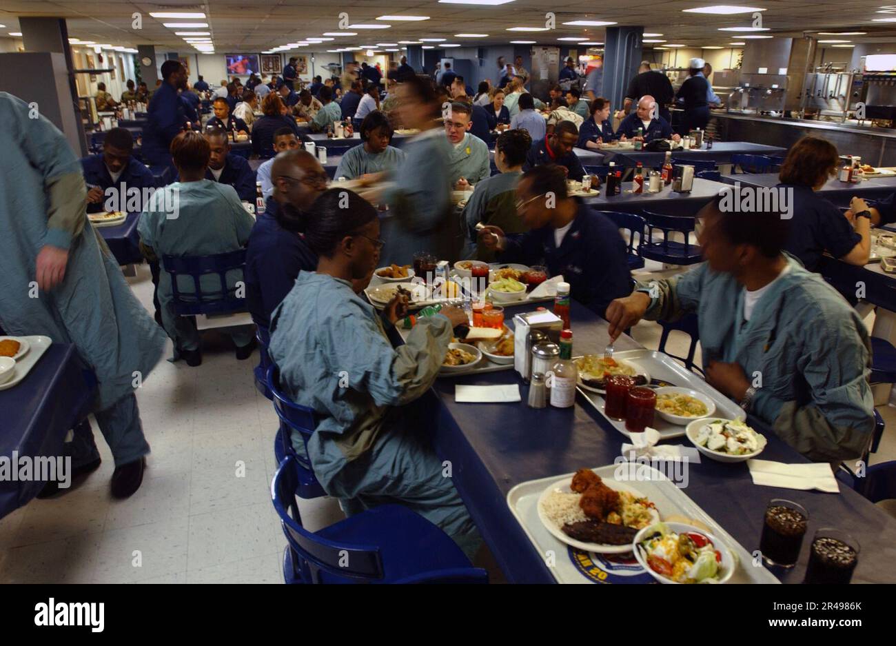 US Navy Crew members take time to get a bite to eat on the mess decks ...