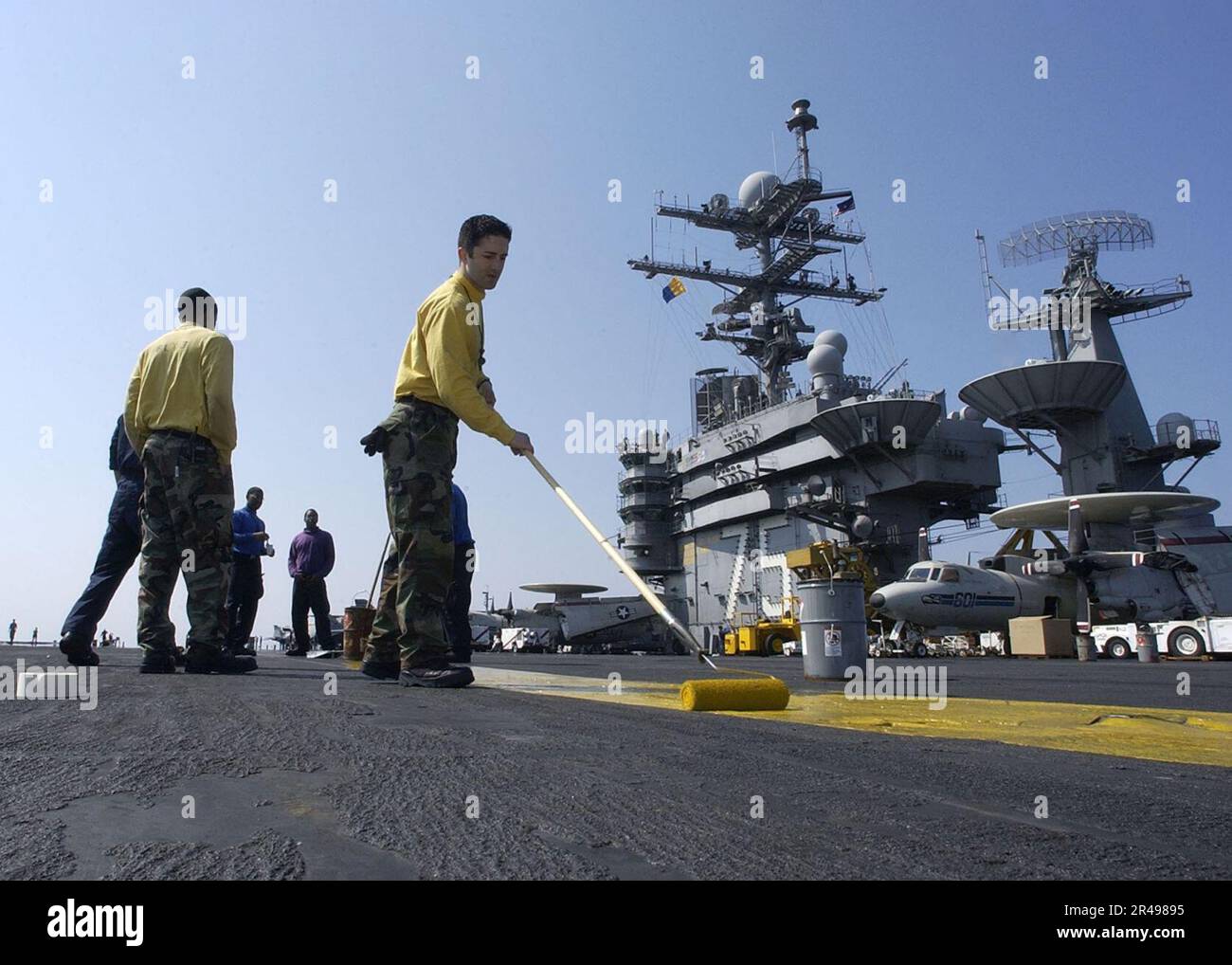US Navy Flight deck personnel repaint the flight line on the flight ...