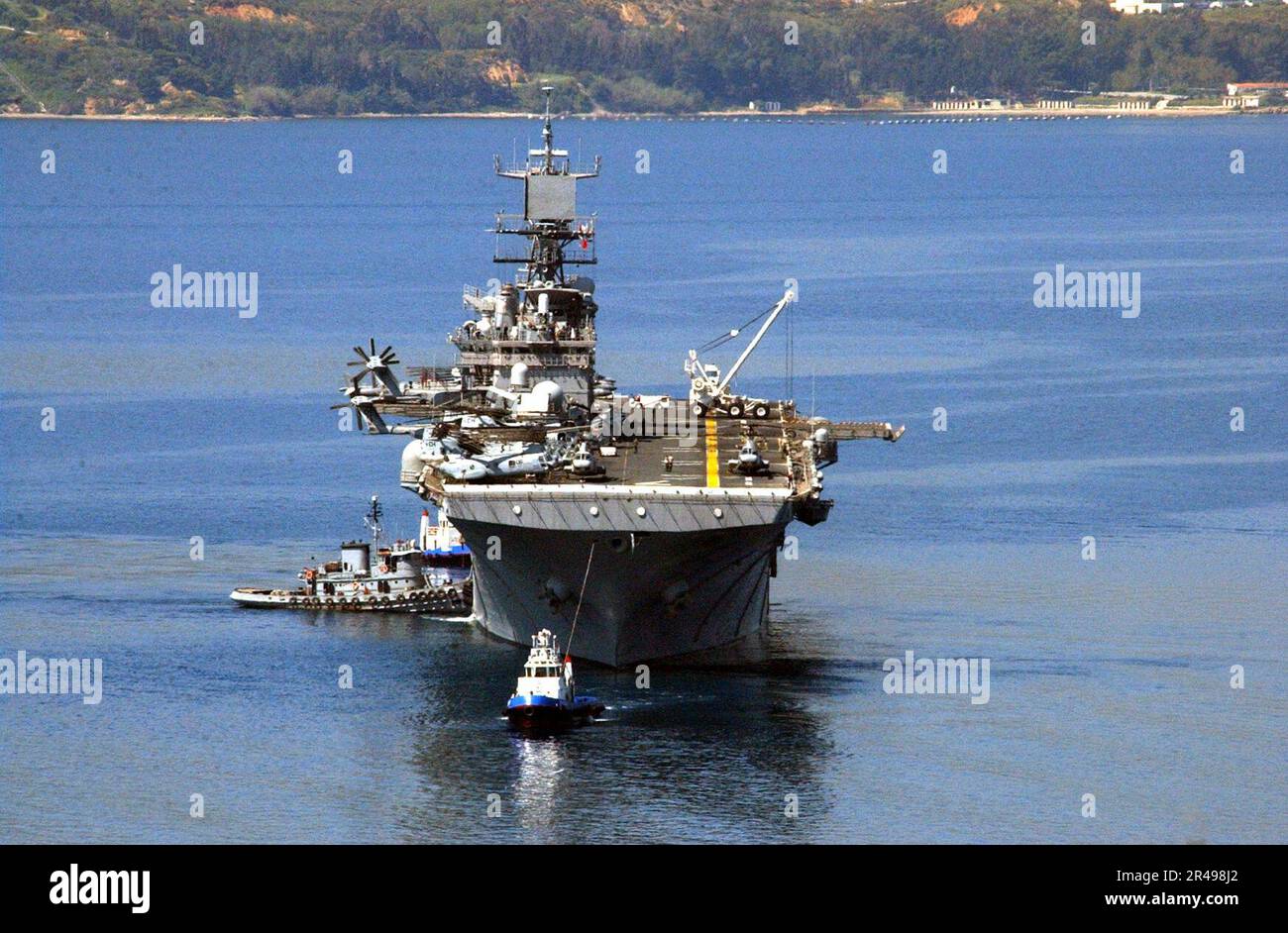 US Navy USS Iwo Jima (LHD 7) is assisted by tugs as she arrives for a ...