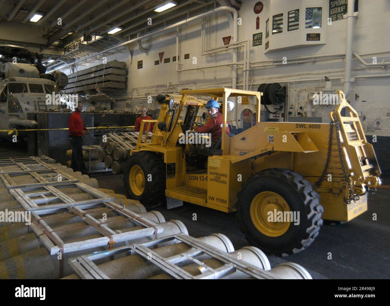 US Navy Aviation Ordanancemen move ammunition from the ship's hangar ...